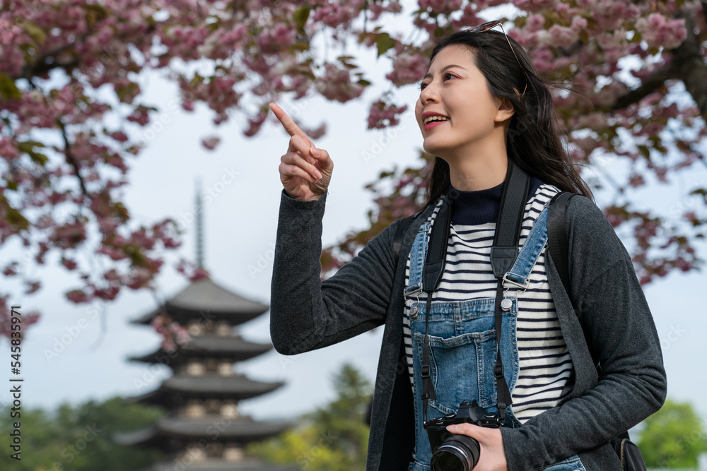 happy asian Japanese female tourist pointing at famous attraction in ...