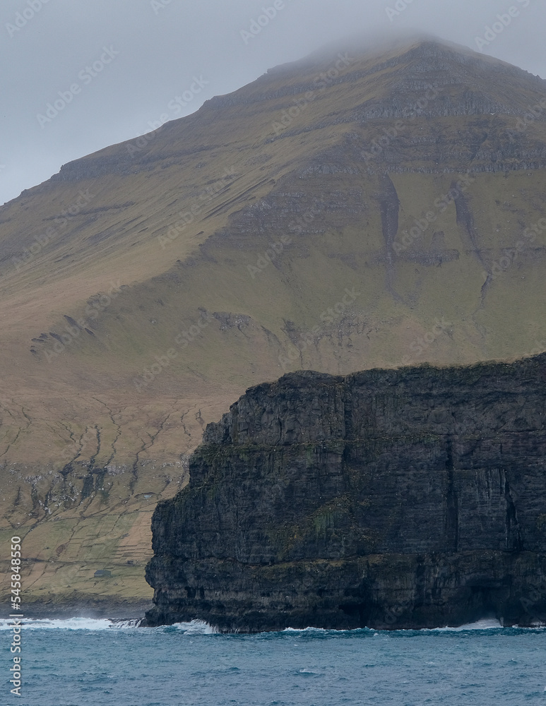 Impressive steep cliffs and rocky coastline silhouette coast of Faroe ...