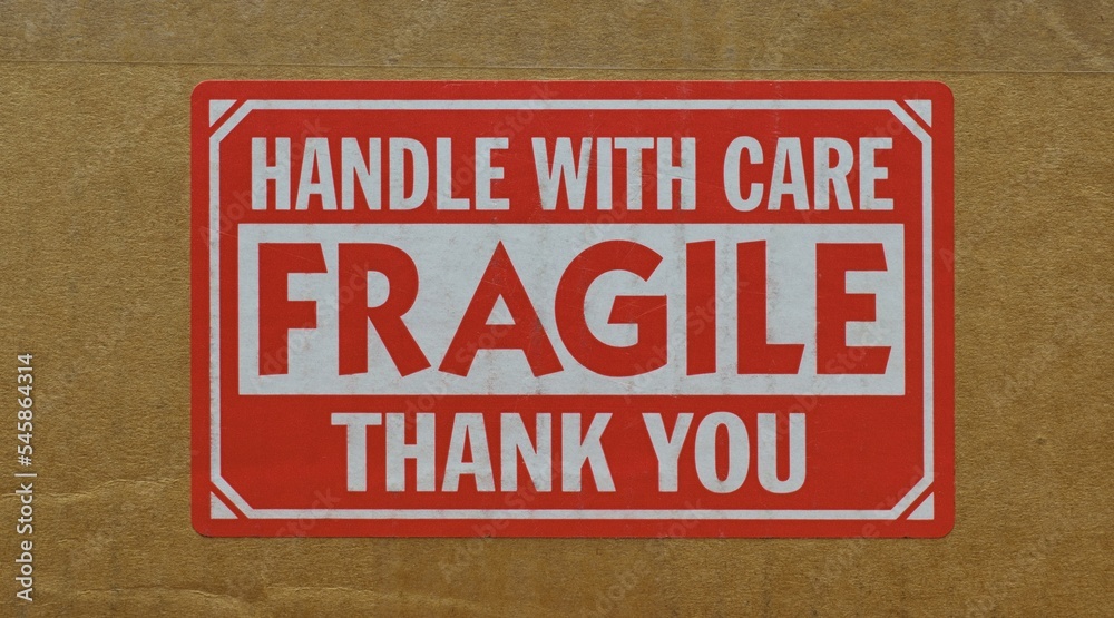Handle with care sticker attached to the side of a cardboard box ...