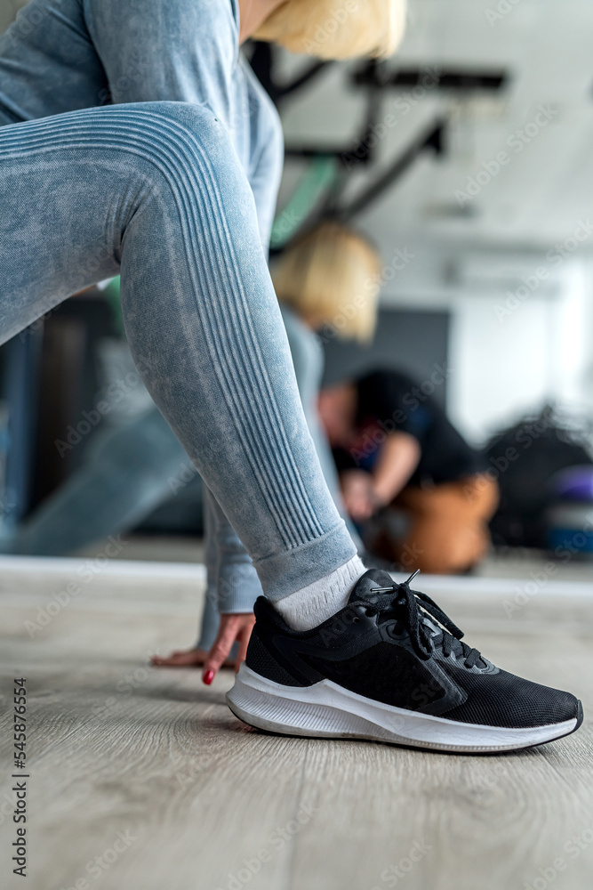 sportswoman in sports leggings and cross-legged flaunts her athletic ...