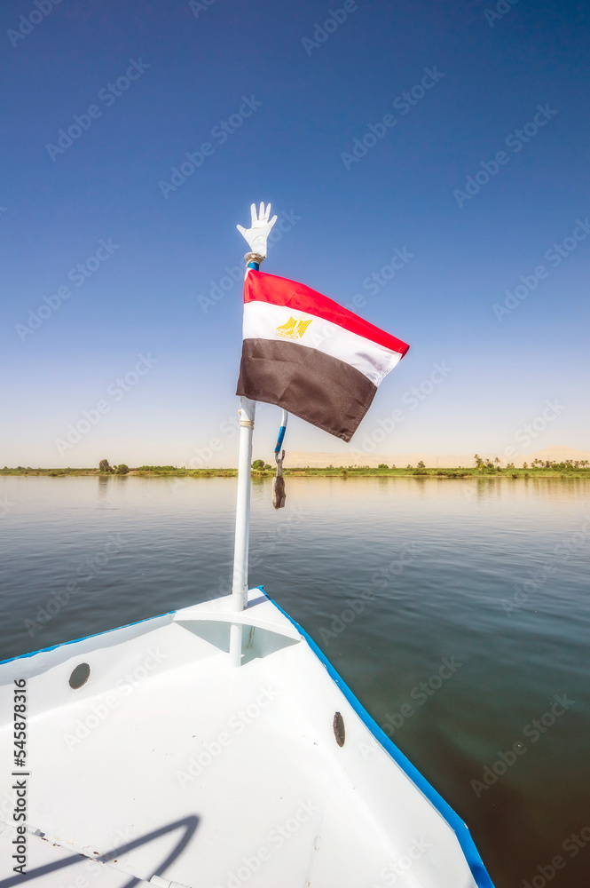 Egypt, Luxor Governorate, Luxor, Egyptian flag on bow of boat floating ...