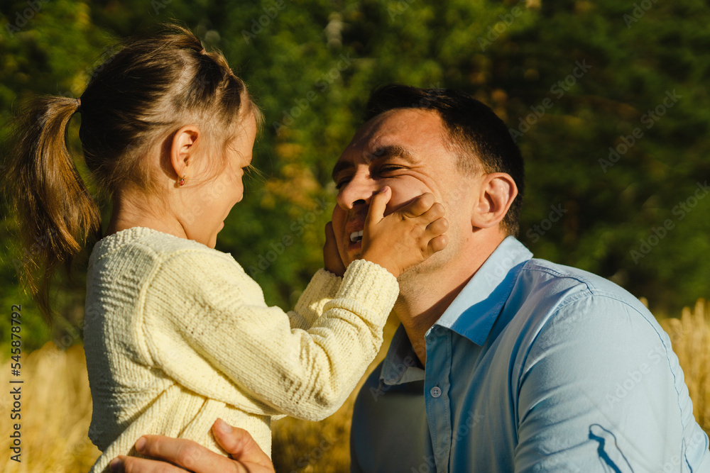Happy girl touching cheeks of father at field on sunny day Stock Photo ...
