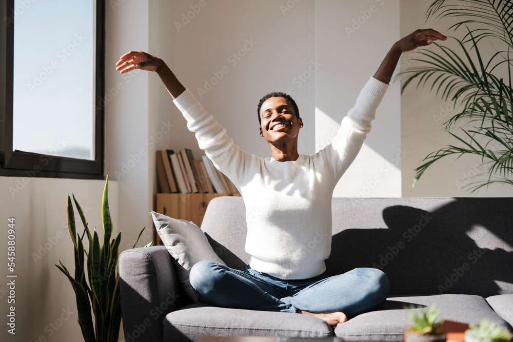 Smiling relaxed woman sitting on couch at home with closed eyes Stock ...