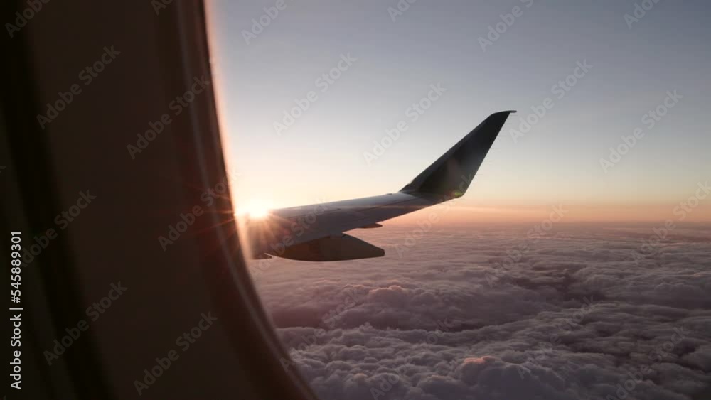Partial reveal of airplane jet wing sun at horizon with len flare of ...