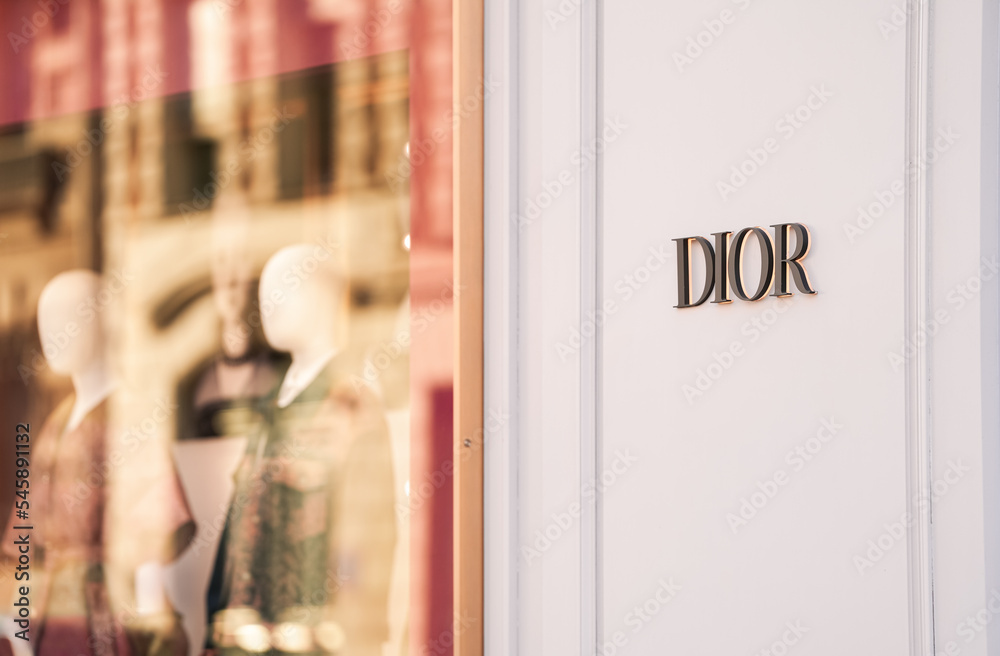 The logo sign of Dior luxury clothing company on top of a store from ...