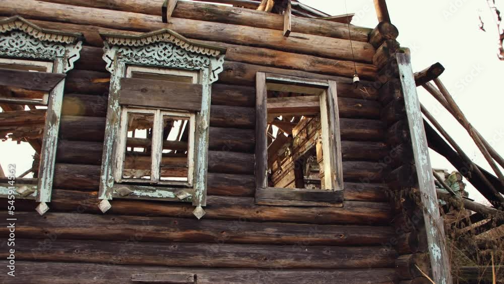 Remains of a destroyed wooden house with glassless windows. Abandoned ...