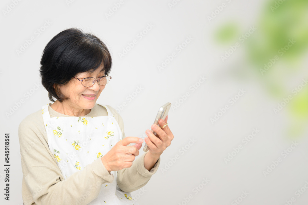 Elderly Asian man smiling and tapping on his phone Green with front ...