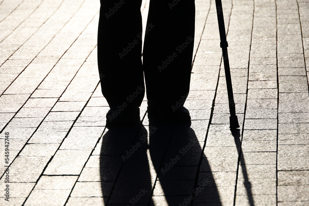 Foto de Silhouette of limping man walking with a cane, black shadow on ...