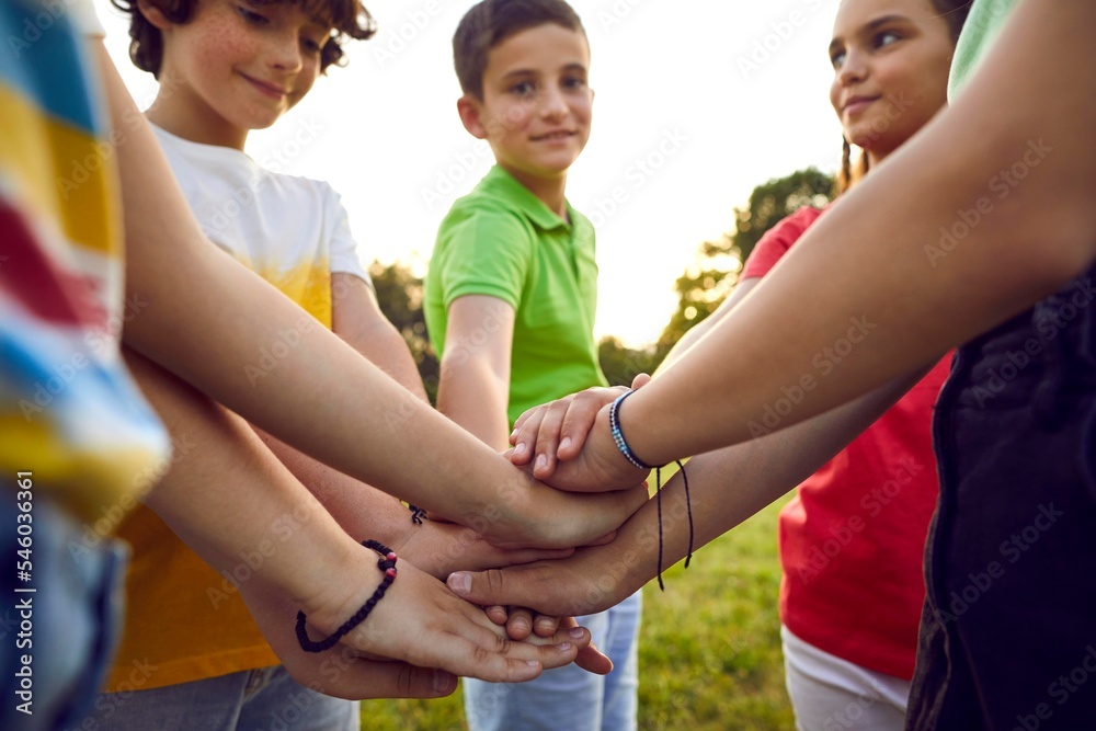 Friend stack hands showing unity and teamwork. Cheerful group of kids ...
