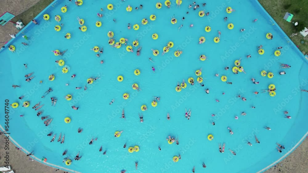 Top view: Lots of people swim and have fun in the big pool under the ...