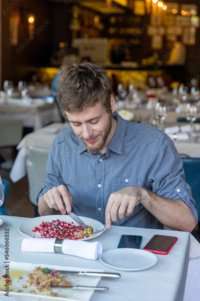 Bearded man eating steak tartare in the restaurant Stock Photo | Adobe ...