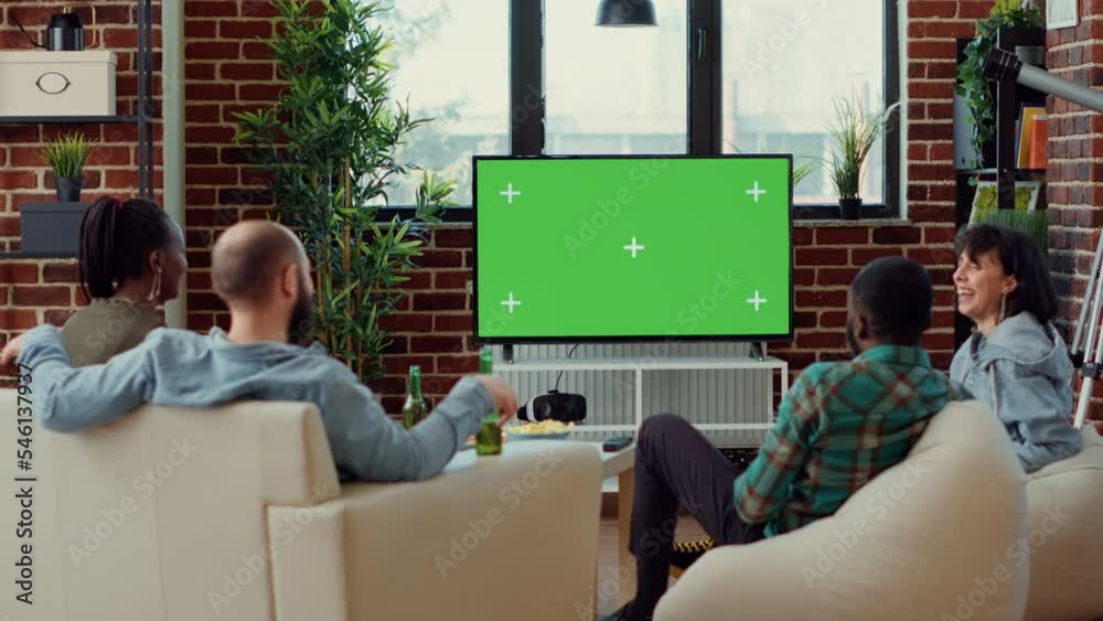Group of people enjoying movie on television with greenscreen template ...