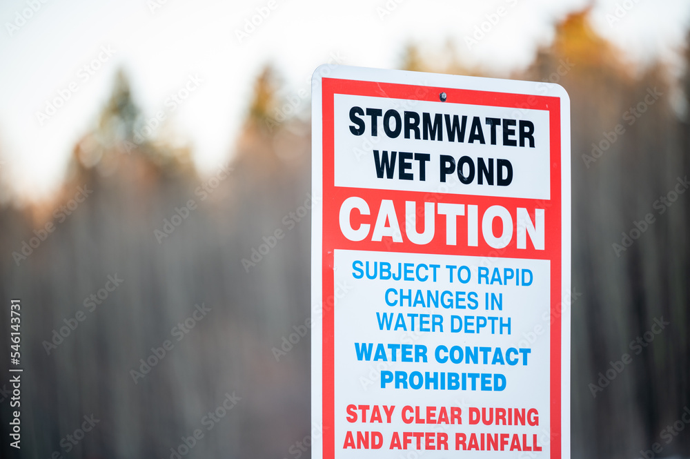 Stormwater wet pond caution sign on wetland edge ภาพถ่ายสต็อก | Adobe Stock