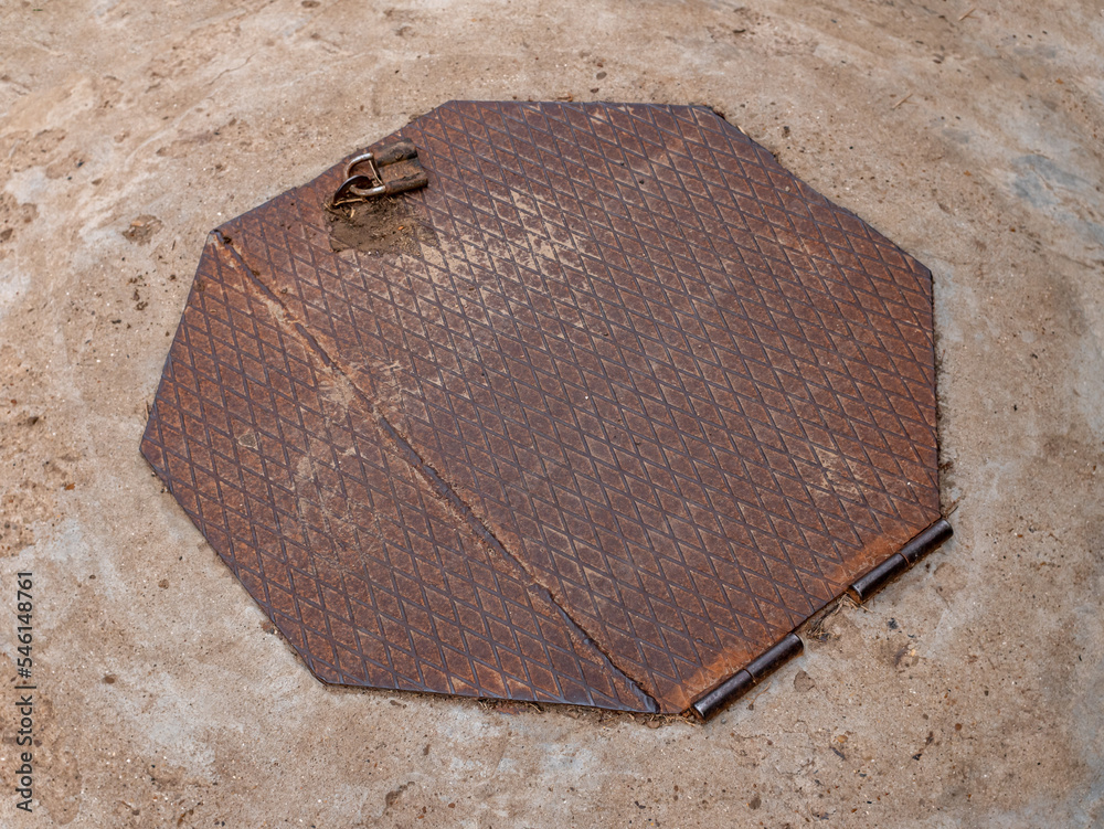 Iron manhole of the city sewer. A rusty manhole on a concrete base ...