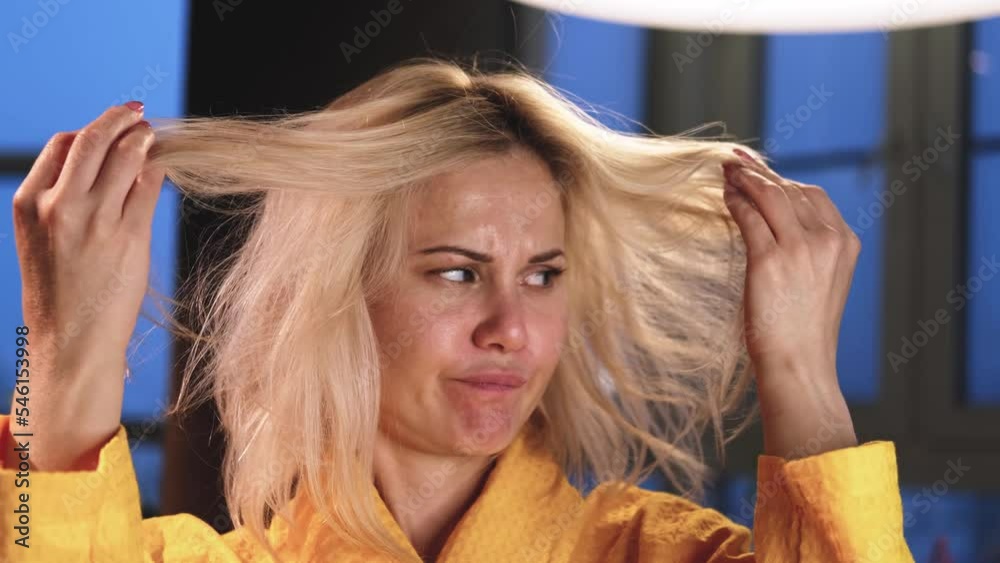 Damaged hair. Sad young woman with tousled hair. Close-up portrait of a ...