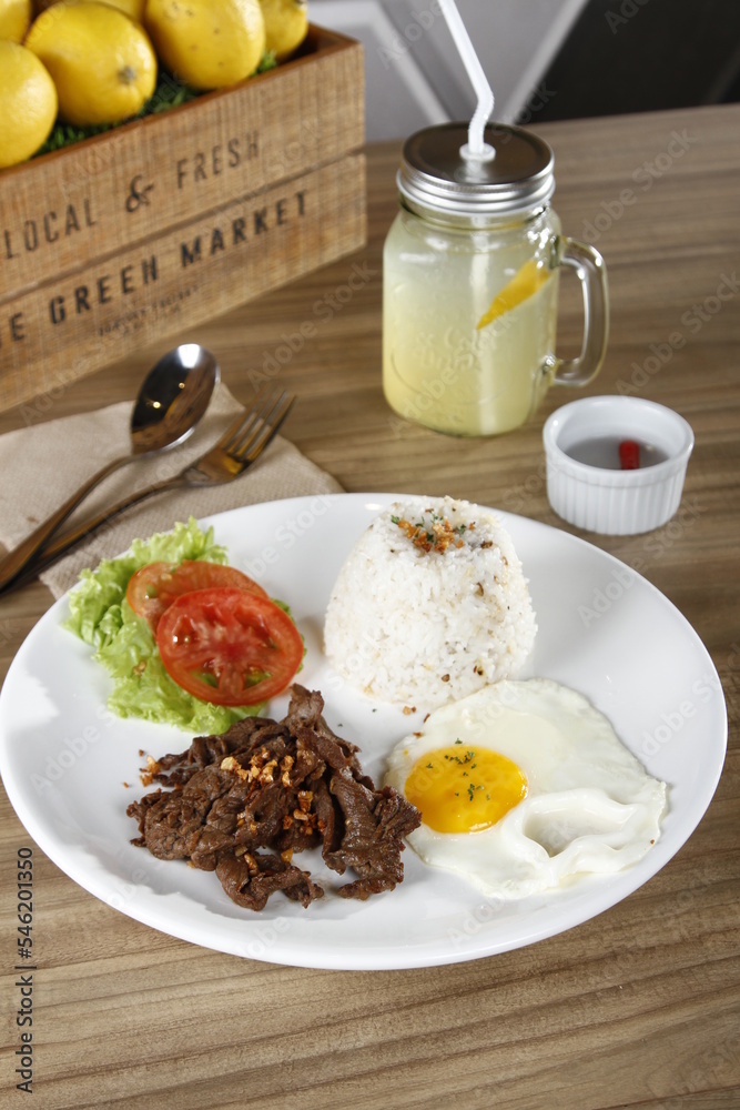 Tapsilog, a Filipino breakfast of beef tapa, fried rice and eggs Stock ...