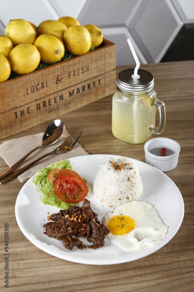 Tapsilog, a Filipino breakfast of beef tapa, fried rice and eggs Stock ...