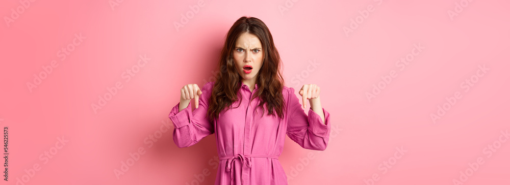 Angry and displeased young woman frowning, gasping offended, pointing ...