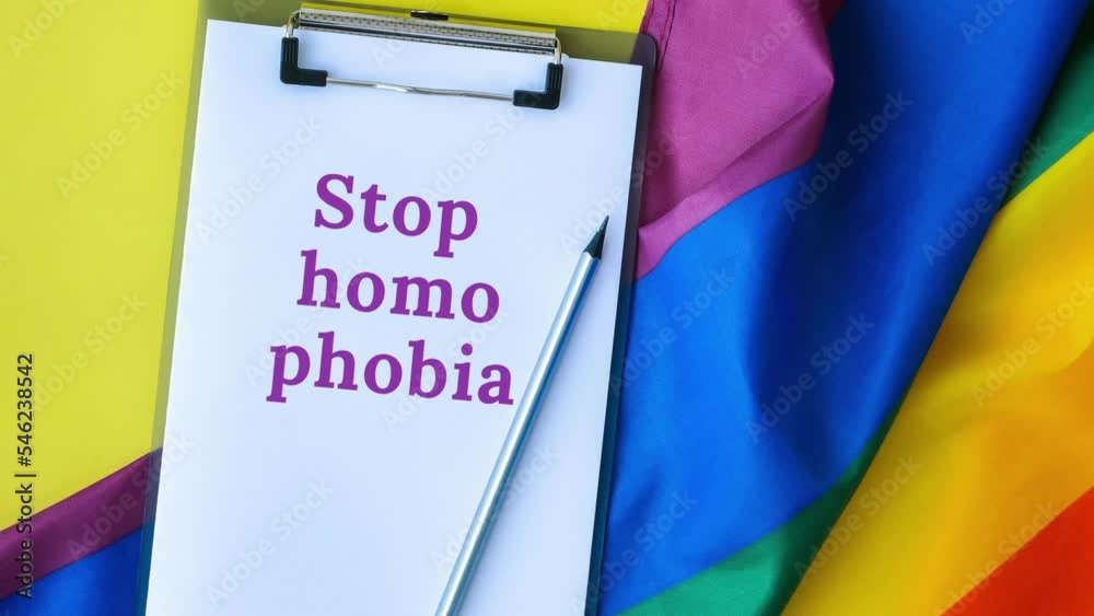 4k zoom in out Rainbow flag with text STOP HOMOPHOBIA message paper ...