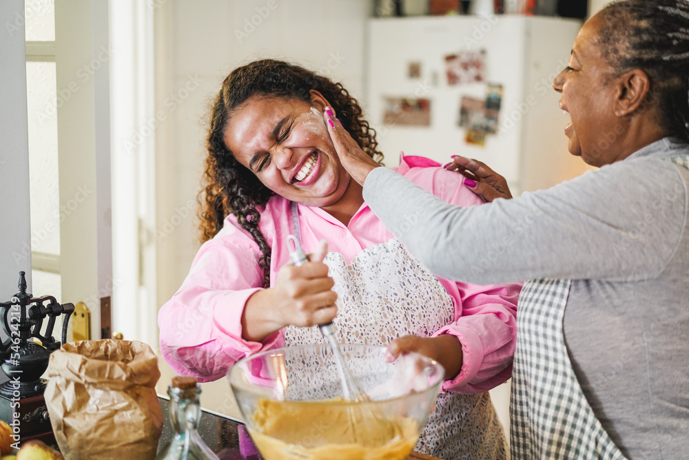 African mother and daughter preparing fruit cake at home - Family and ...