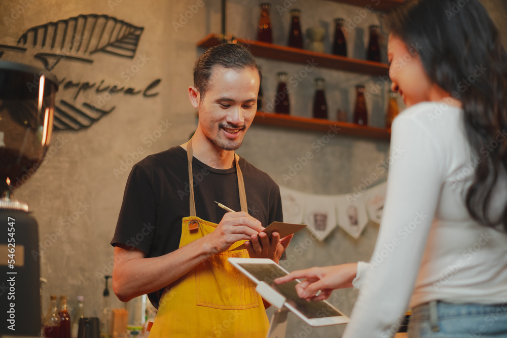 Male barista talking receive orders from customer at bar counter in ...