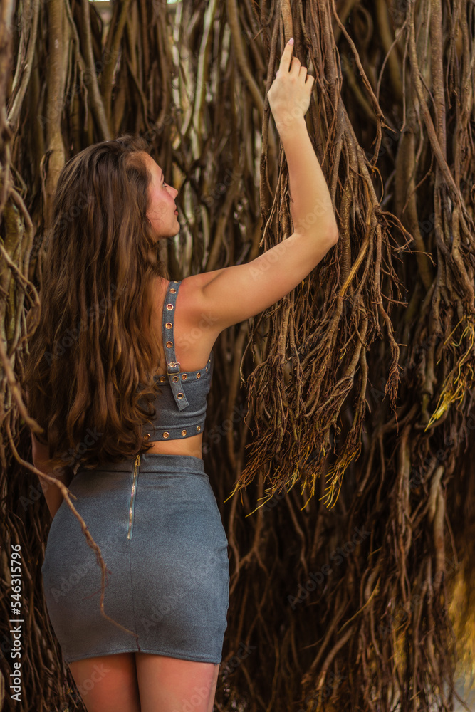 Fashion model girl posing in the jungles dressed in mini skirt and crop ...