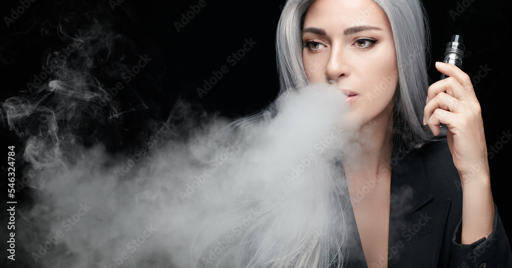 Smoking girl with a vaping device. Silver haired woman blowing a big ...