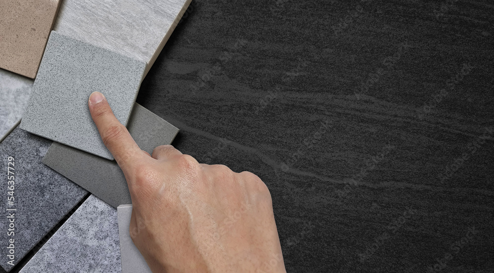 architect's hand pointing to multi color of artificial stones and stone ...