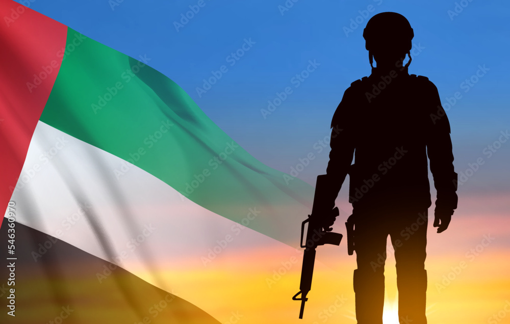 Silhouette of a soldier on background of the sunrise and UAE flag ...