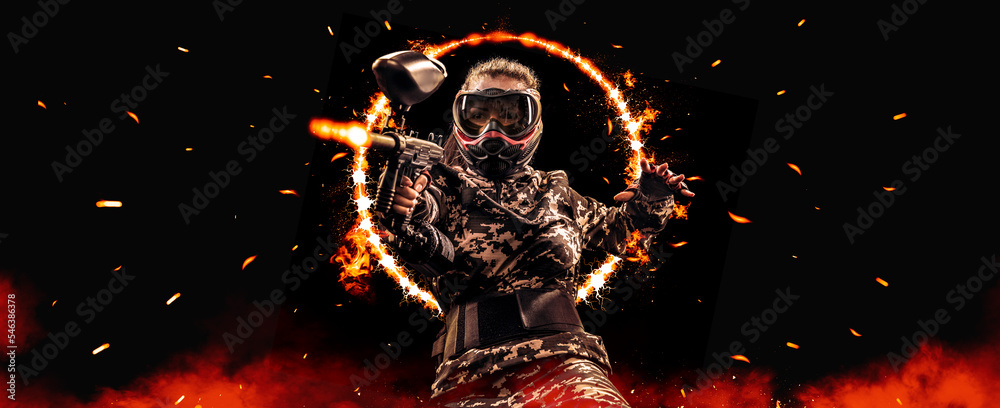 Paintball player woman. Heavily armed masked paint ball soldier on fire ...