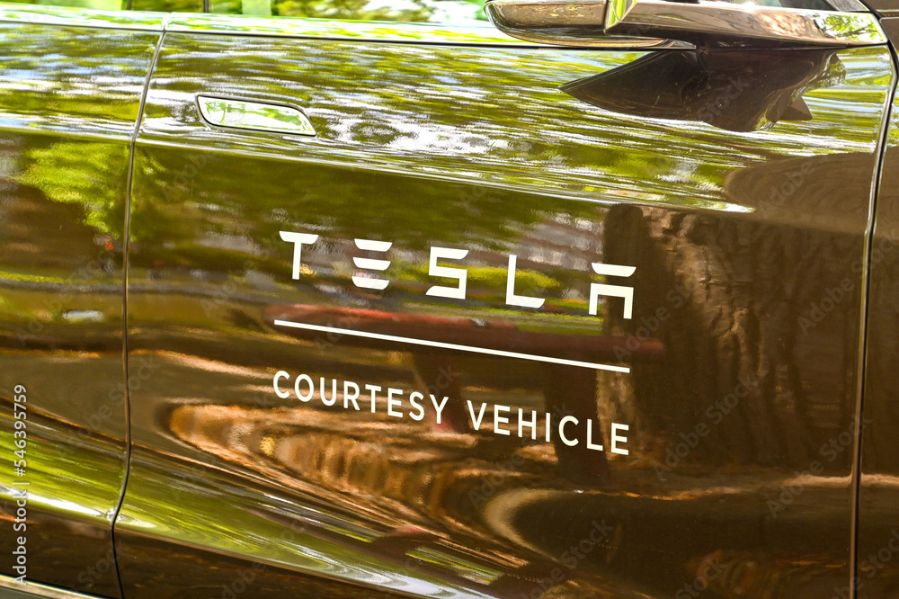 Sign on the side of a Tesla electric car provided to customers of a ...
