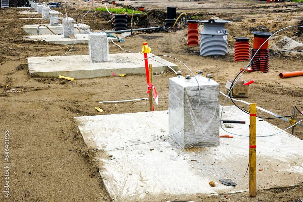 Row of concrete footings for steel columns at the construction site of ...
