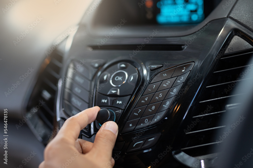 Driver's hand controls car stereo with automatic climate and ...