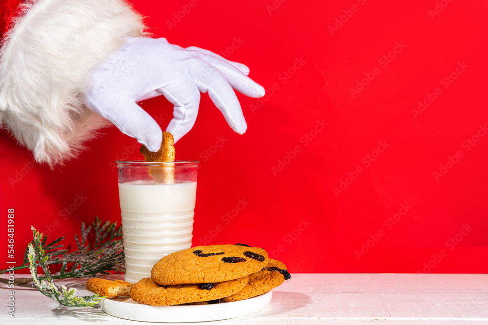 Hand of Santa Claus with traditional Christmas cookie snack with milk ...