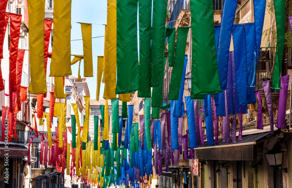 european street, decorated with hanged colorful ribbons in lgbt flag ...