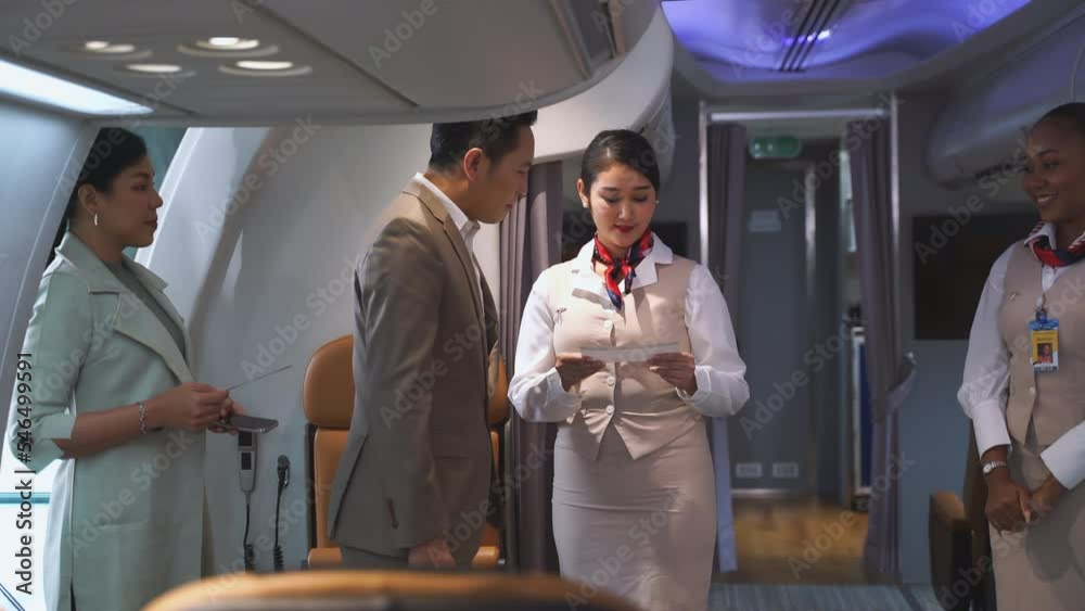 Passengers boarding the plane with boarding pass checked by flight attendants while welcoming at ...