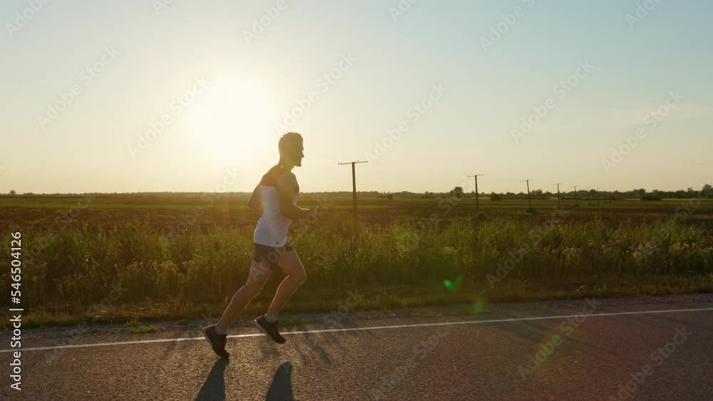 Side view of sporty male running, jogging, training endurance in road ...