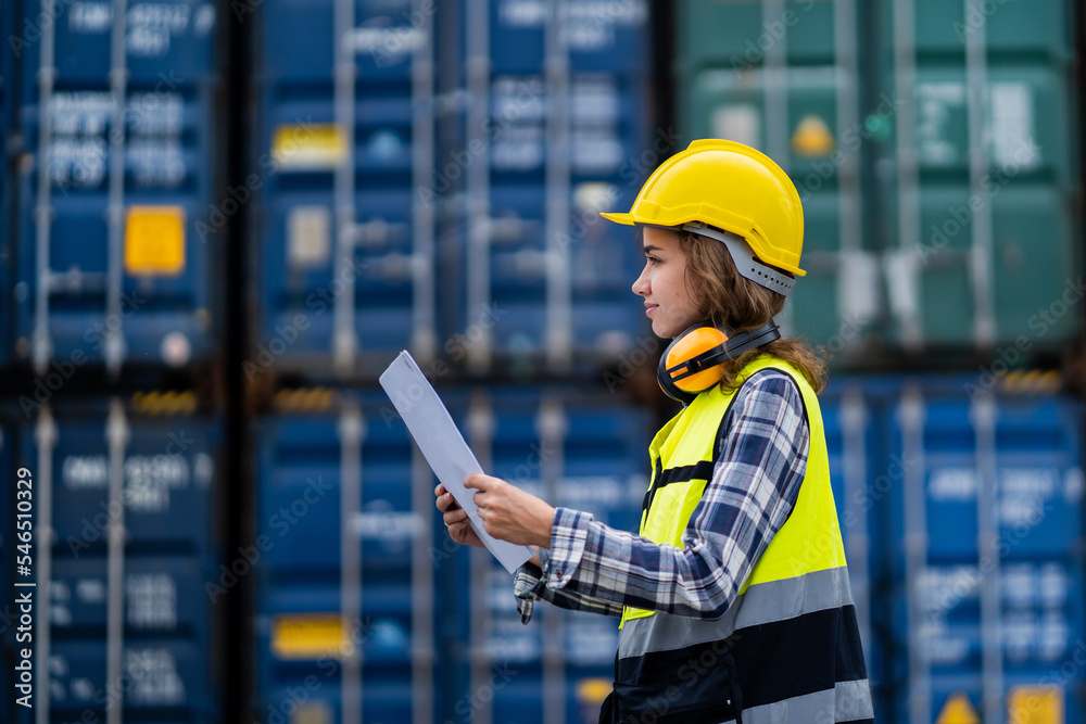 Female engineer checking safety in a large port warehouse. Female ...