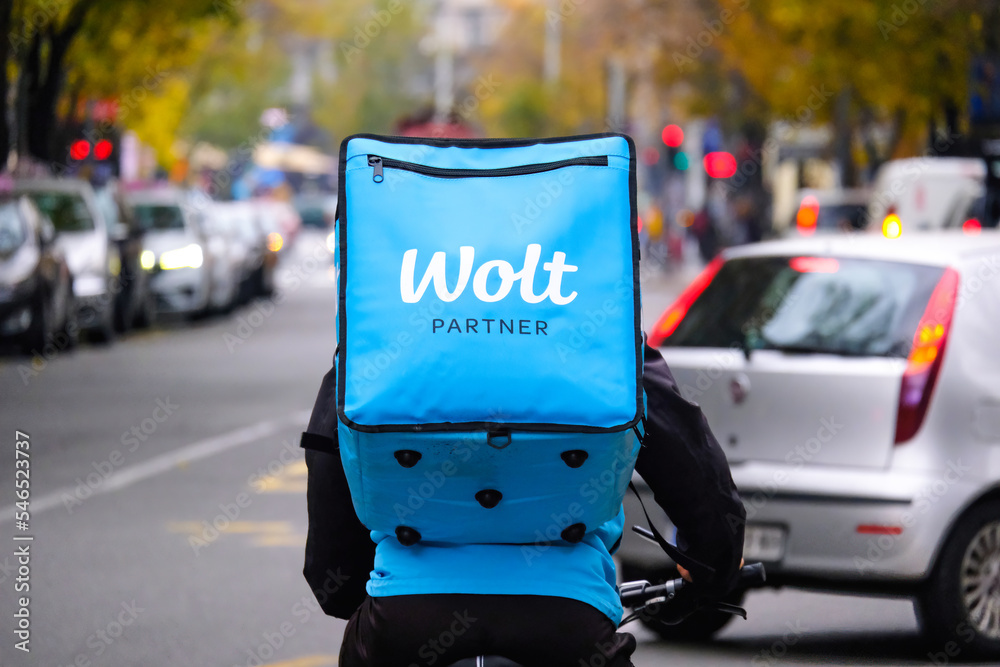 Wolt Delivery Service employee riding a bike with branded box backpack ...