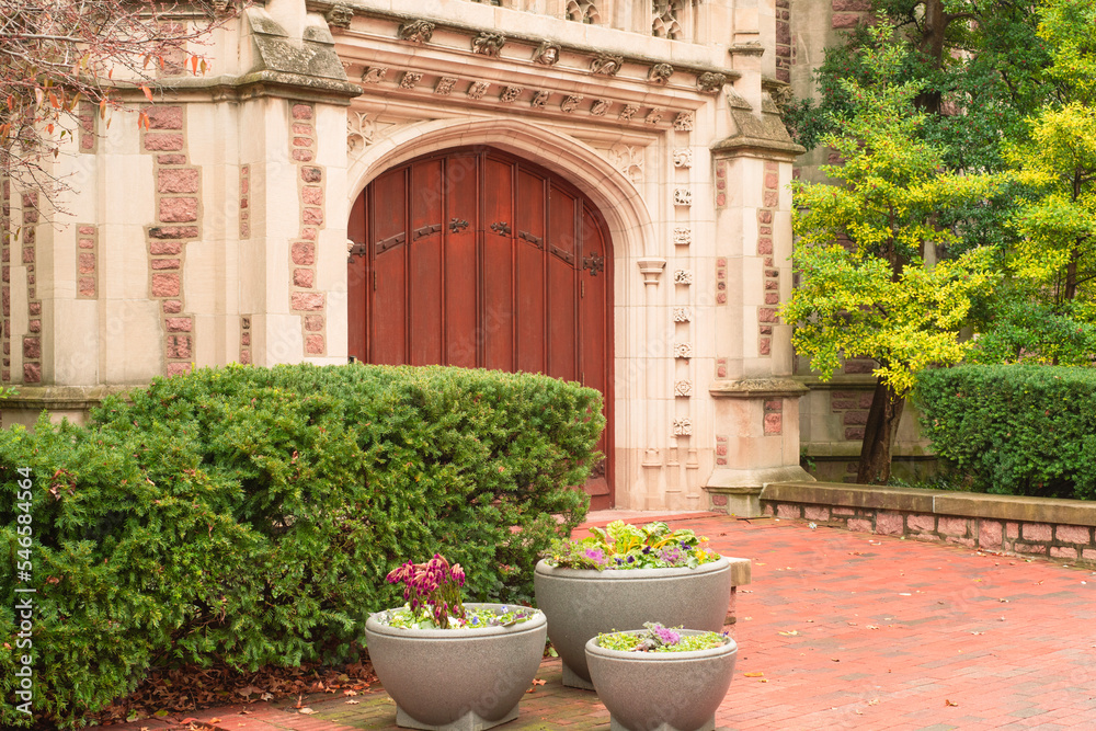 Heavy dark brown double doors of a chapel. Red brick leading up to the ...