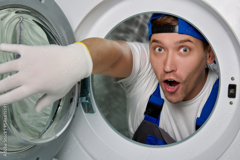 With his mouth open in surprise, a young man in a work uniform and ...