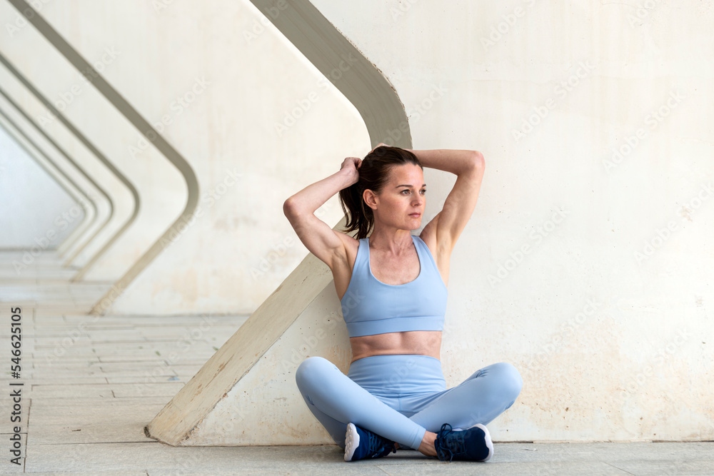 Fit sporty woman tying her hair up before running and exercise outside ...