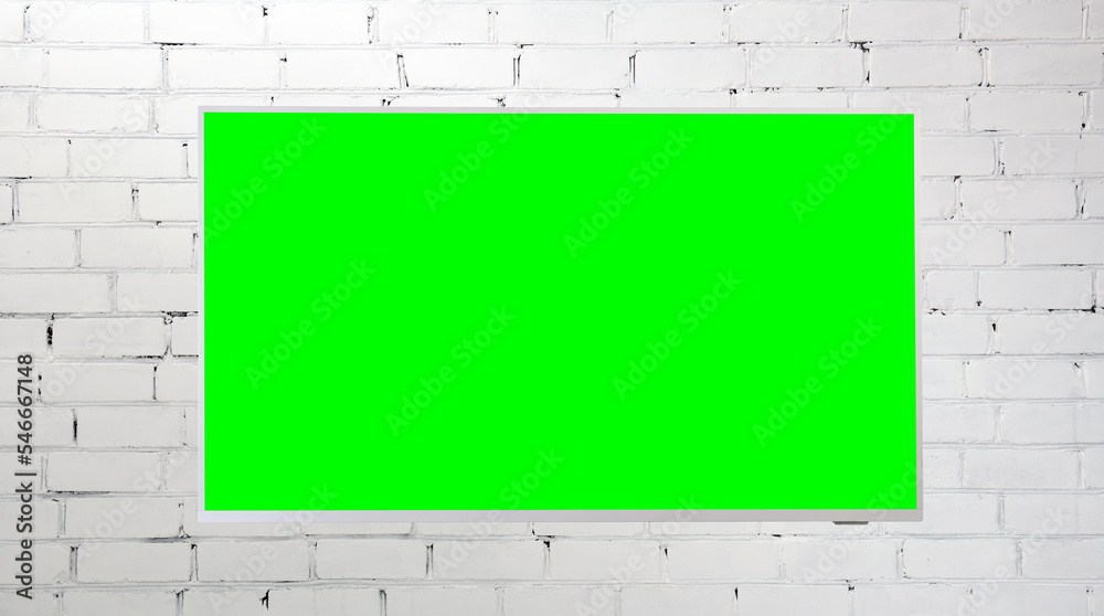 Green screen LED TV on a brick white wall indoors. Living room. The ...