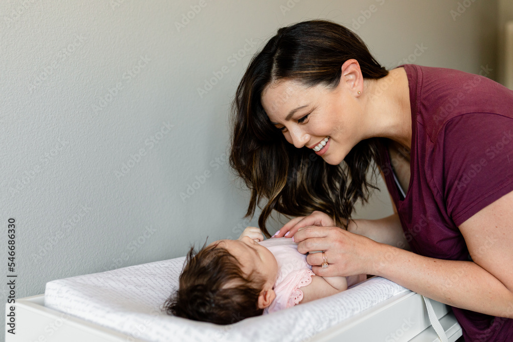 Smiling Mother Interacts With Baby On A Diaper Changing Table Stock ...