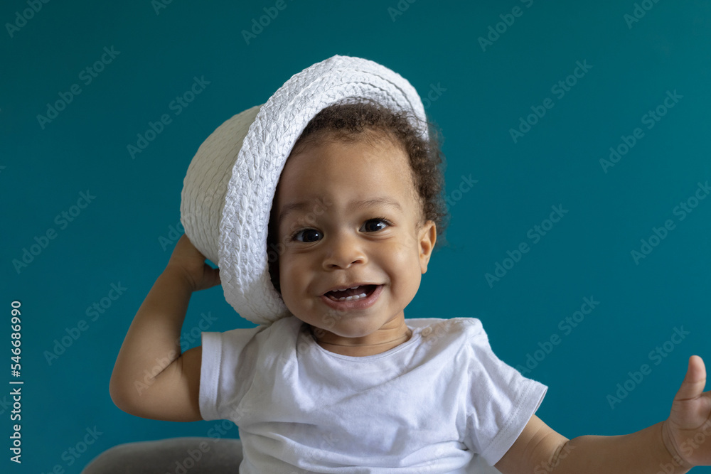 surprised smiling one year old baby portrait in hat, fashion child boy ...
