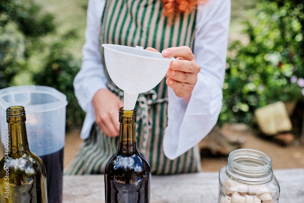 Hands placing a funnel in a wine bottle Stock Photo | Adobe Stock