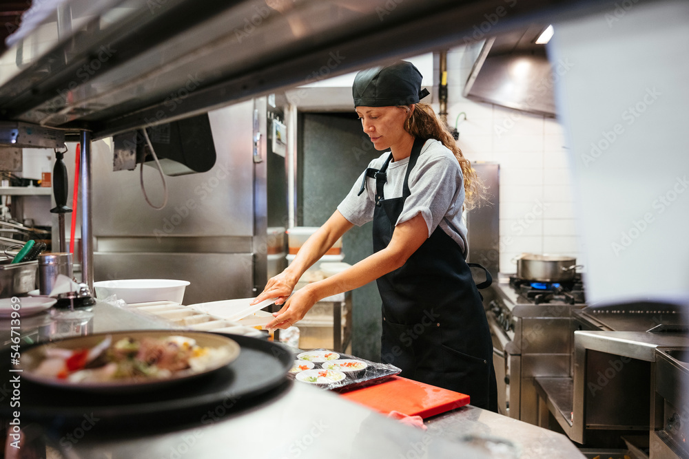 Female chef opening box in restaurant kitchen Stock Photo | Adobe Stock