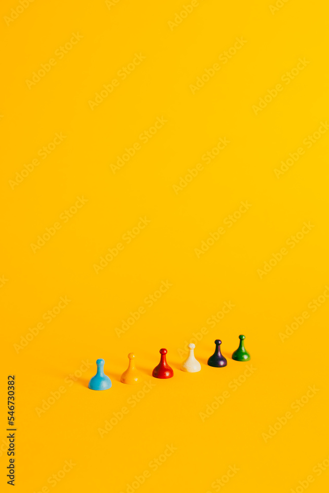 Colorful Board Game pieces diagonally on a vibrant yellow background ...
