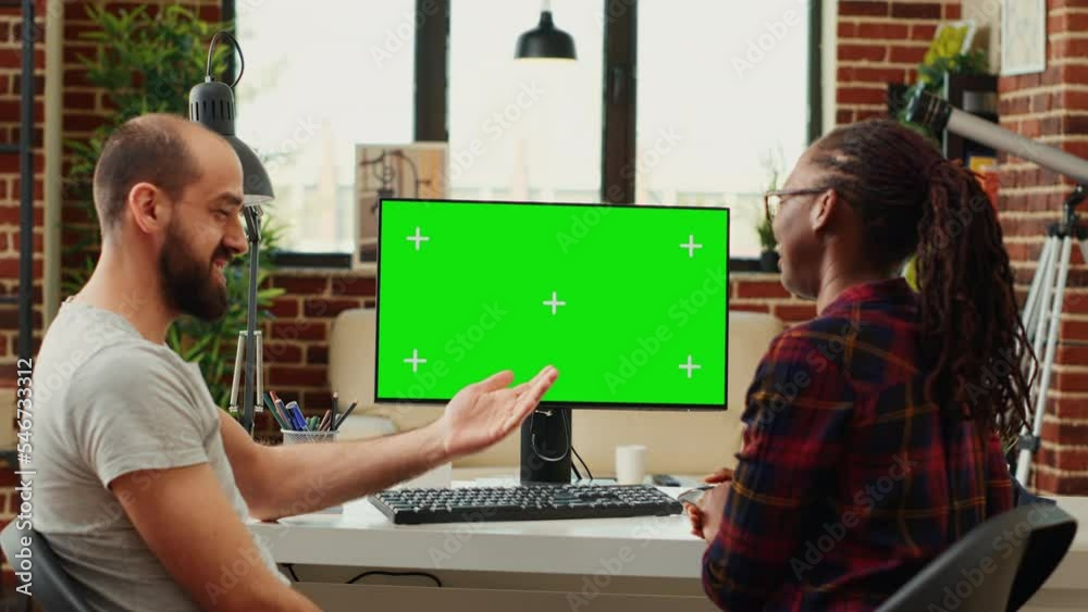 Diverse colleagues working with greenscreen display on computer ...