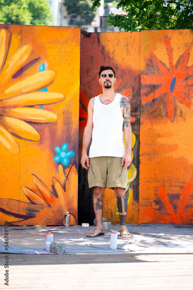 Graffiti artist portrait in front of mural they are painting Stock ...